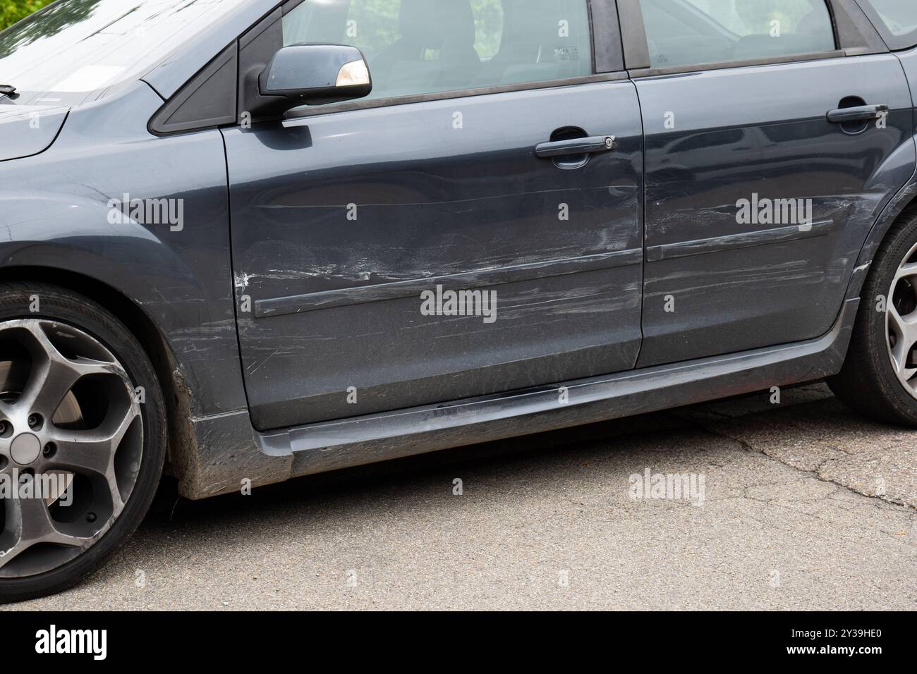 Dented and scratched car wheel arch bodywork. Generic car, front view ...