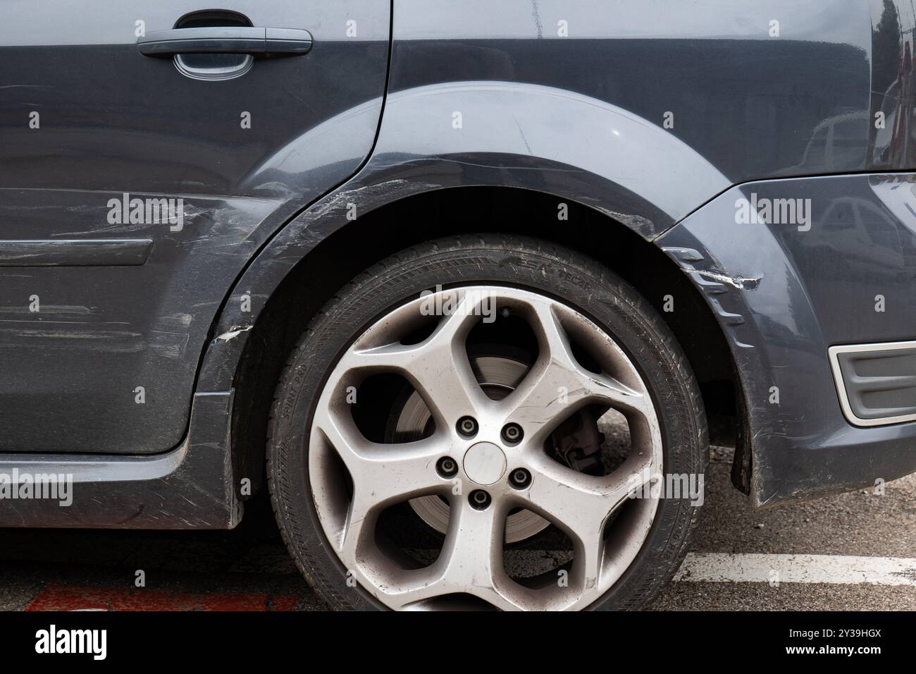 Dented and scratched car wheel arch bodywork. Generic car, front view ...
