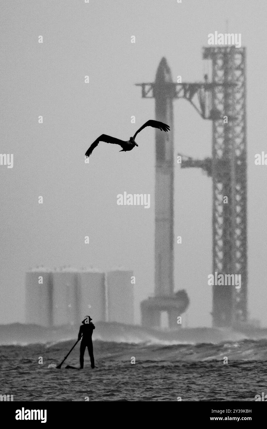 A black and white photograph of a paddleboarder on the ocean with a ...