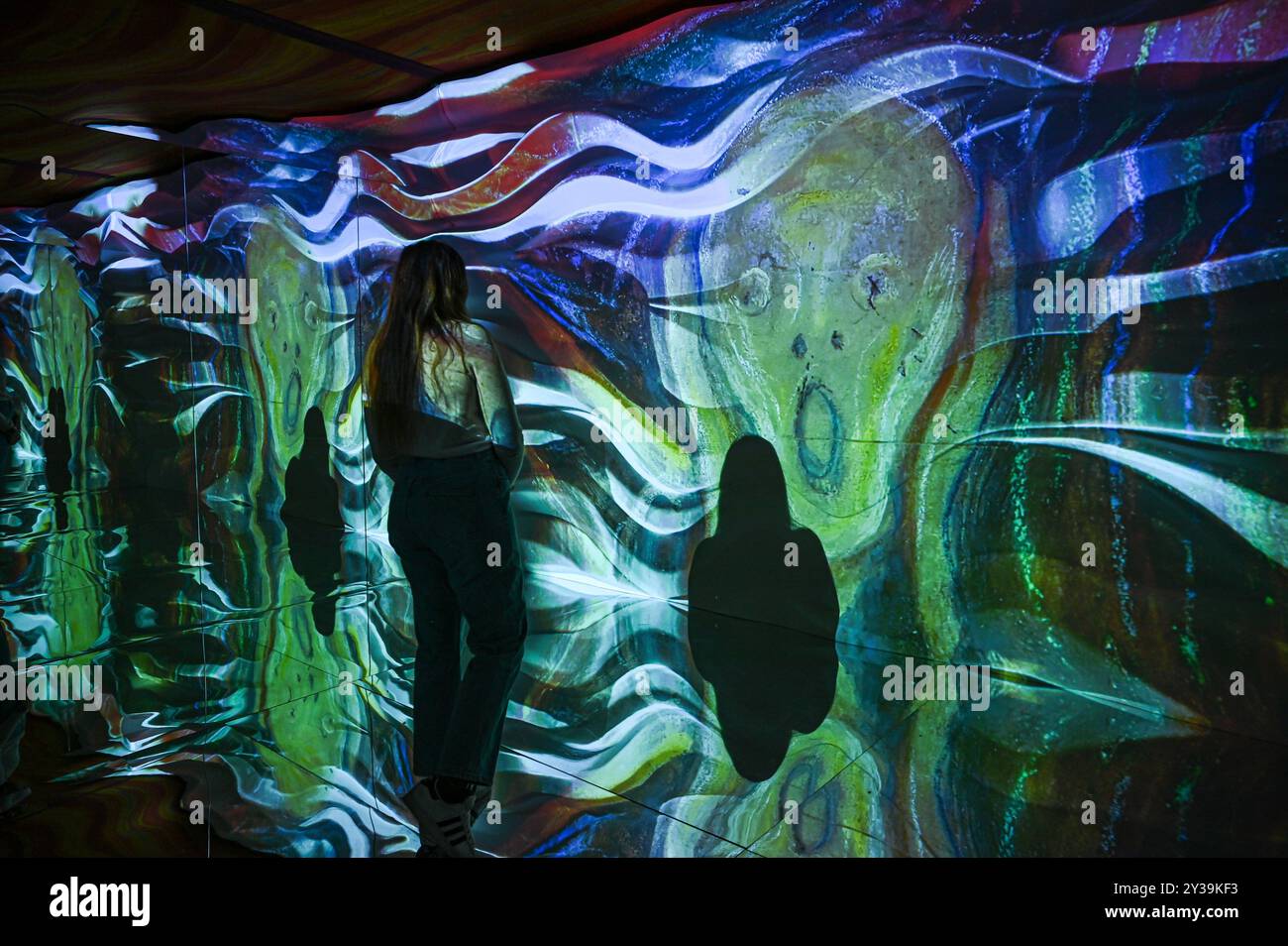 A visitor reacts next to an immersive projection of 'The Scream' during ...