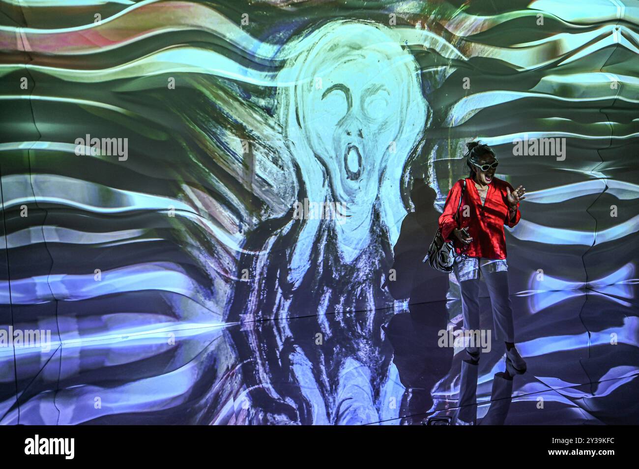 A visitor reacts next to an immersive projection of 'The Scream' during ...