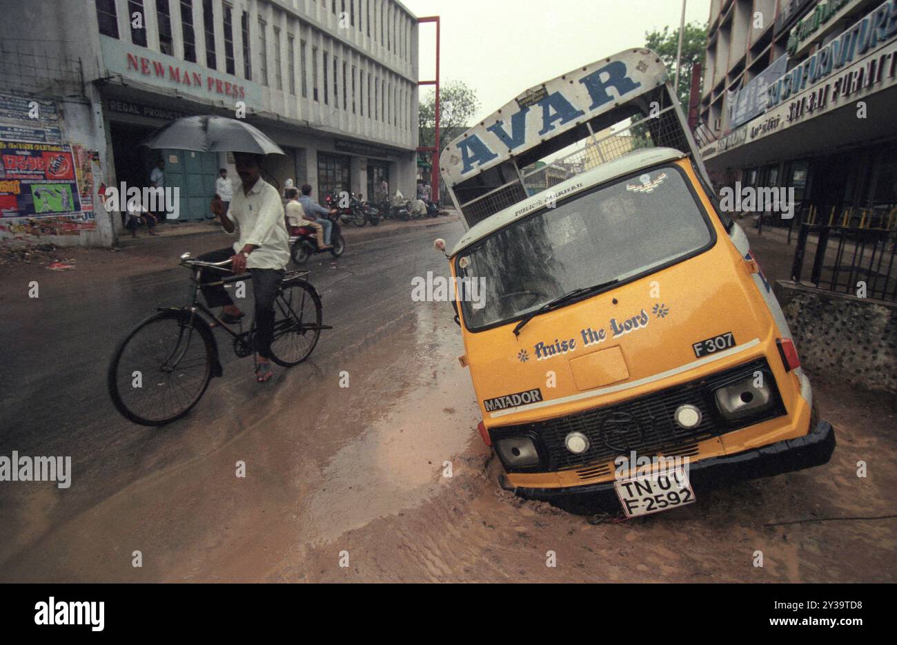 a car accident with a hole in the road by rain showers in the city ...