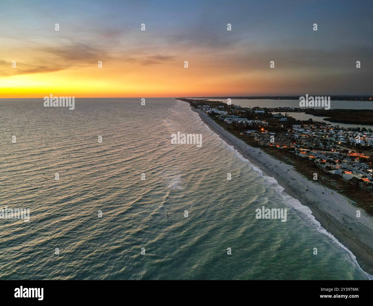An aerial view of coastal houses lining the beach stretching to the ...