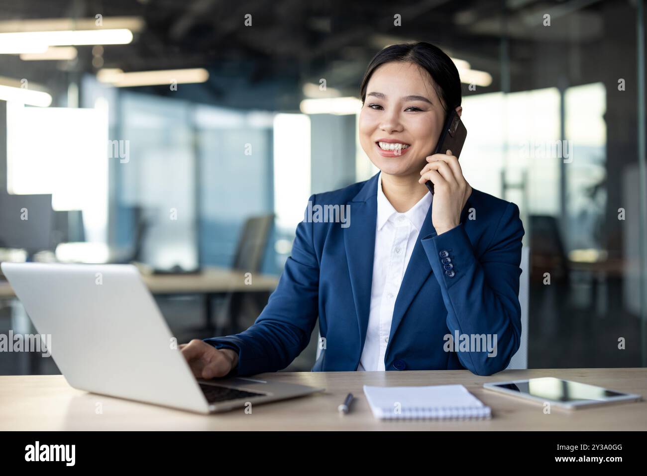 Asian businesswoman engaged in phone conversation. Smiling confidently ...