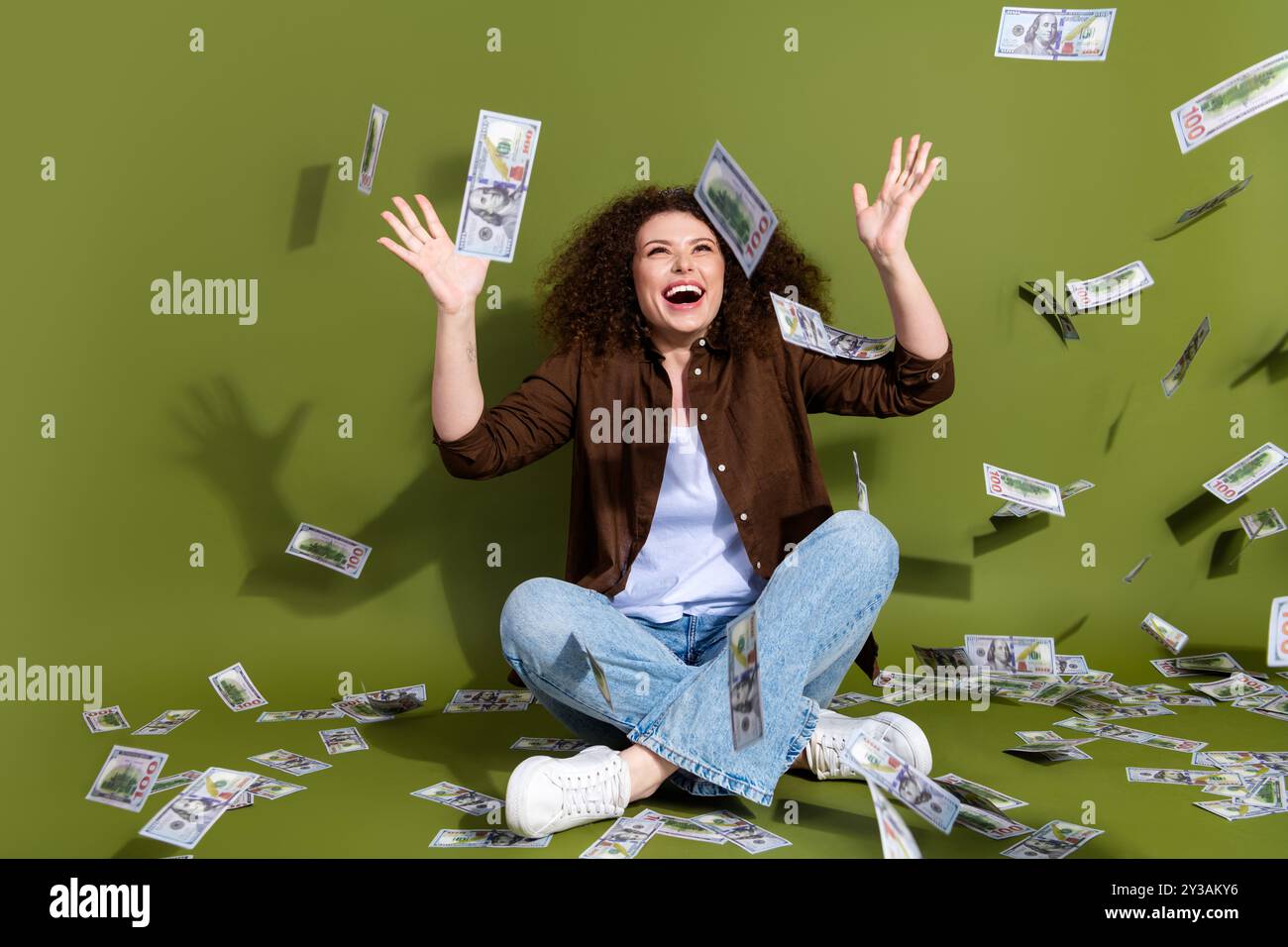 Full body portrait of nice young girl sit floor flying money isolated ...