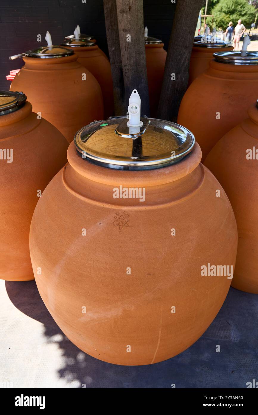 A detailed view of large earthenware jars with metal lids, under the ...