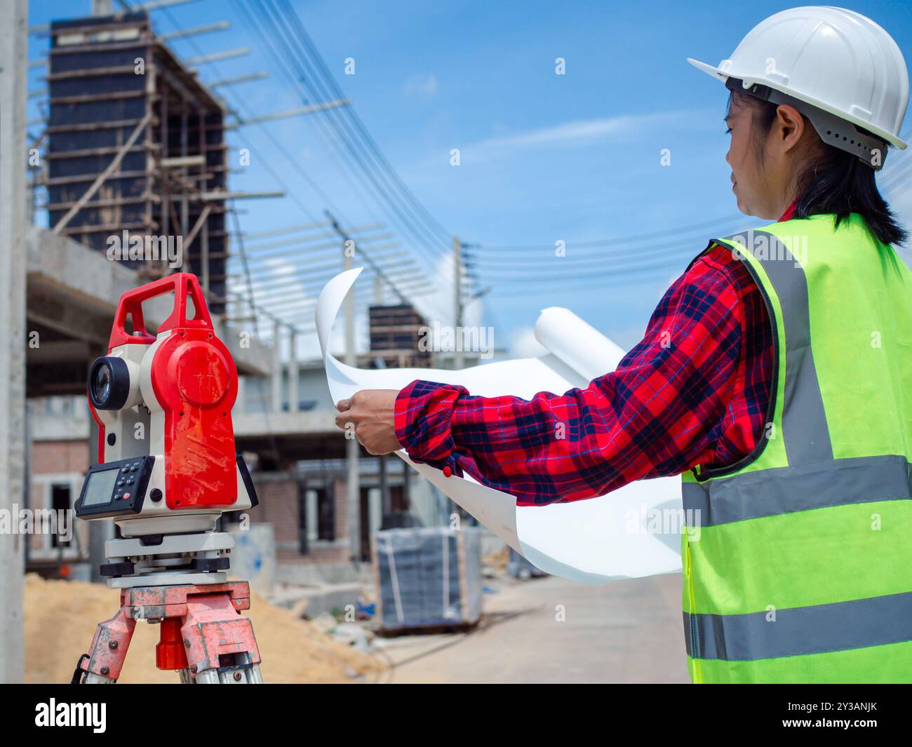 Engineers holding blueprint project working outdoors building side with ...