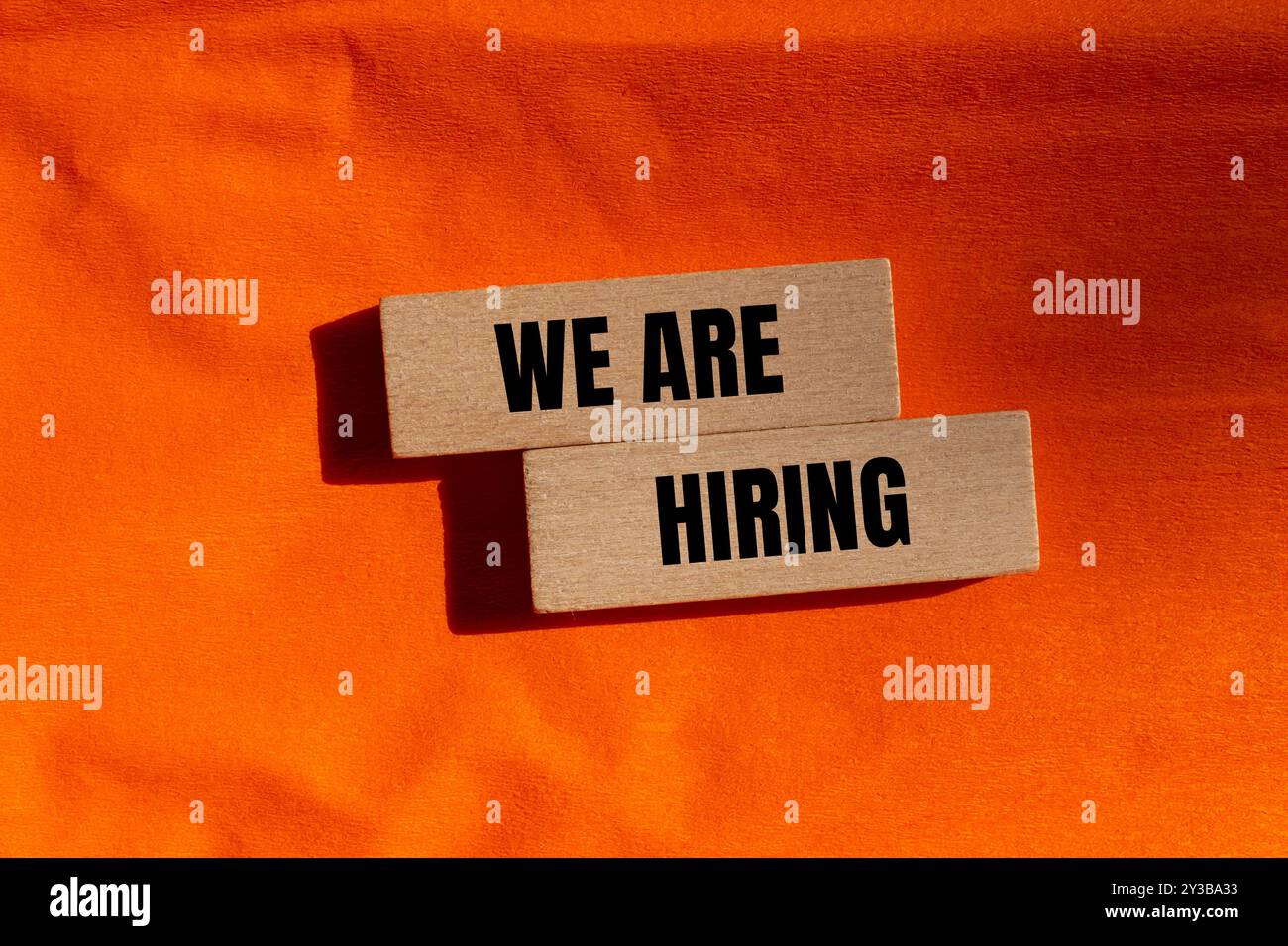We are hiring message written on wooden blocks with orange background. Conceptual we are hiring ...