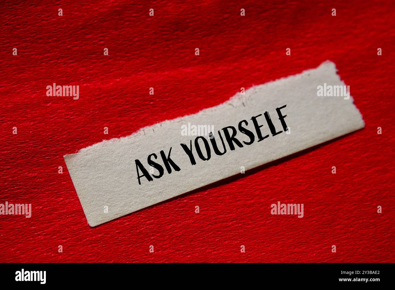 Ask yourself message written on torn paper with red background ...