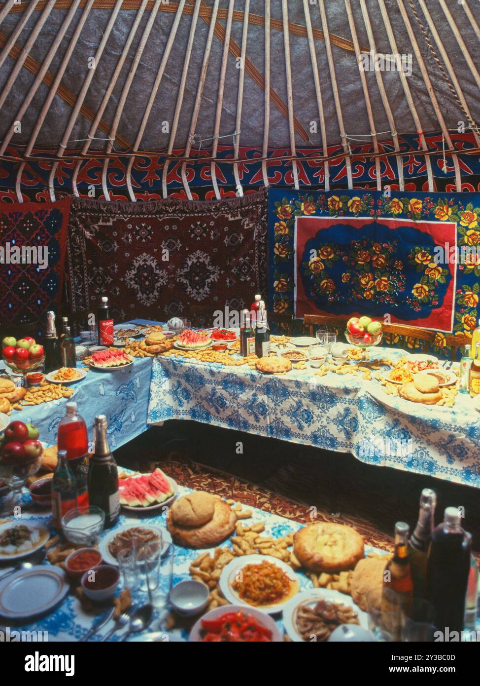 Traditional Kyrgyz interior of a yurt showcasing a festive food spread ...