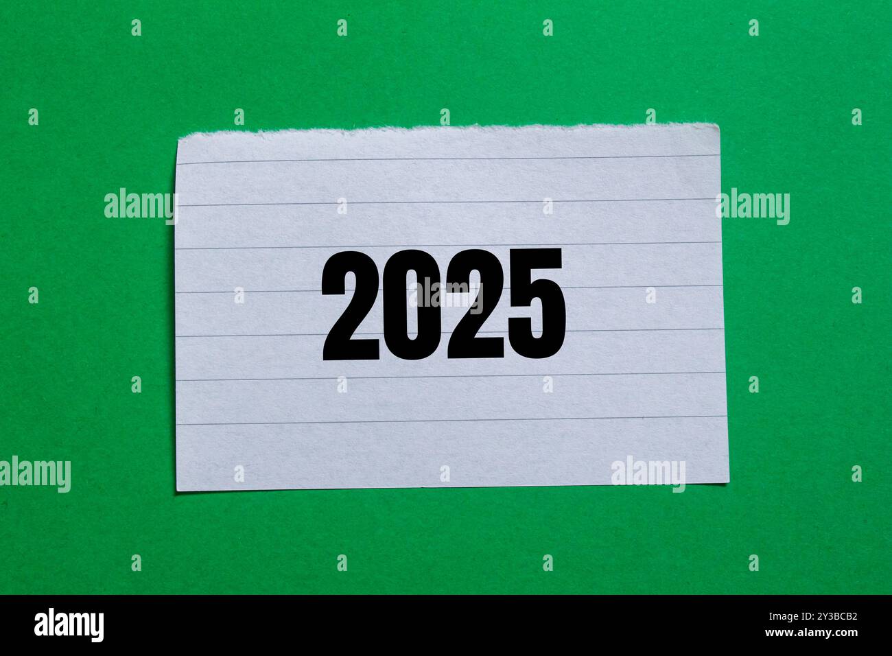 2025 message written on ripped torn paper piece with green background. Conceptual 2025 symbol ...