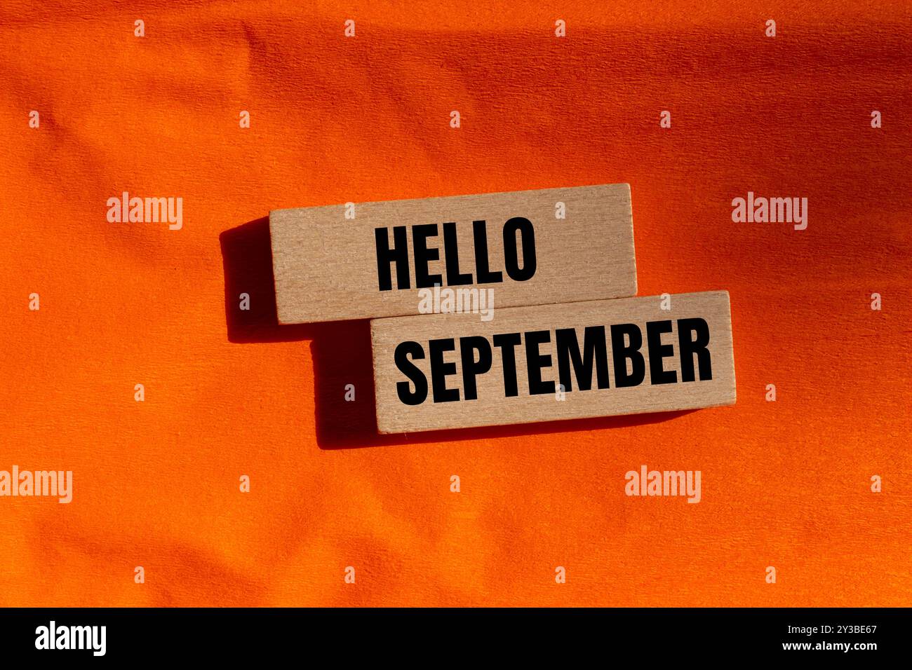 Hello september message written on wooden blocks with orange background ...