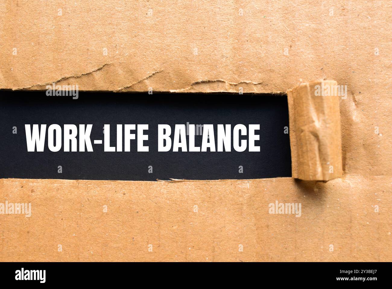 Work life balance message written on ripped torn cardboard paper with black background ...