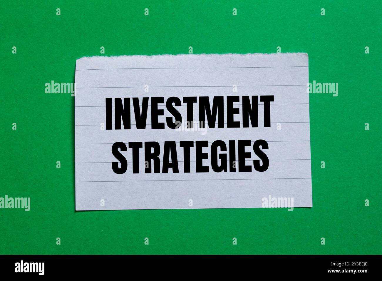 Investment strategies message written on ripped torn paper piece with ...