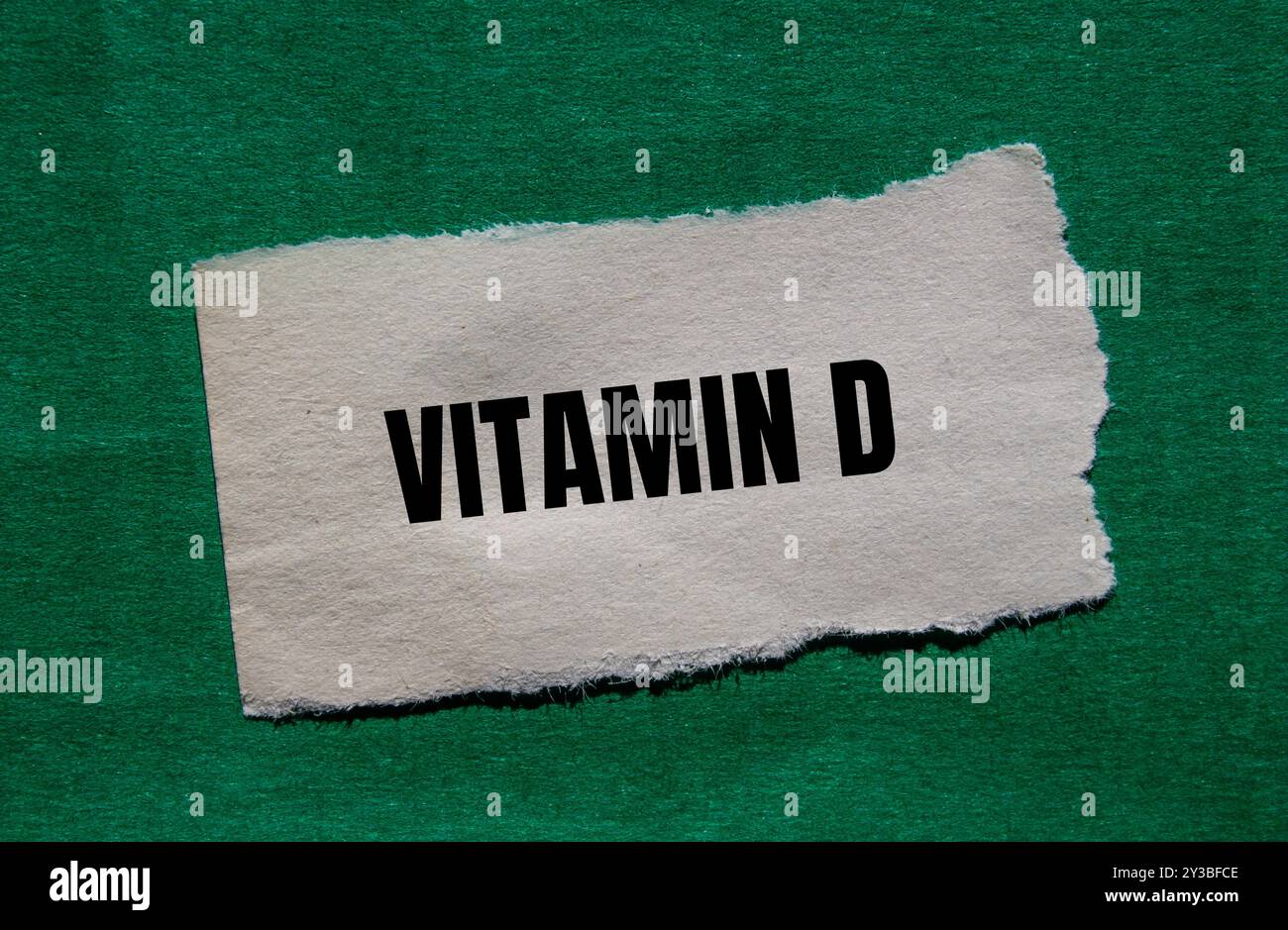 Vitamin d message written on ripped torn paper piece with green ...