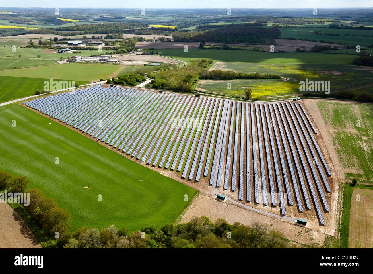 Aerial image showcasing an extensive solar farm set amidst lush green ...