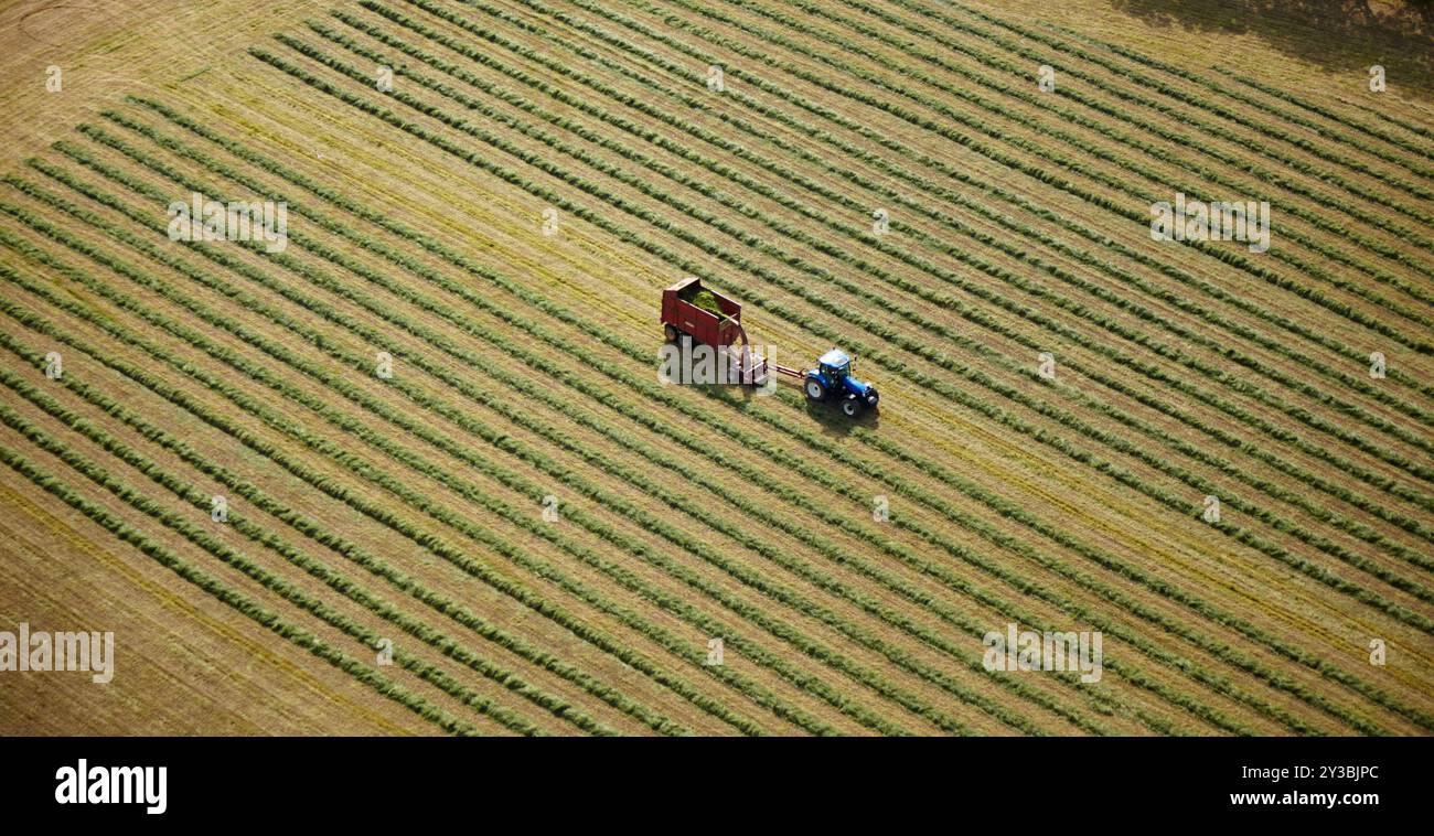 A tractor and trailer working in a segmented agricultural field ...