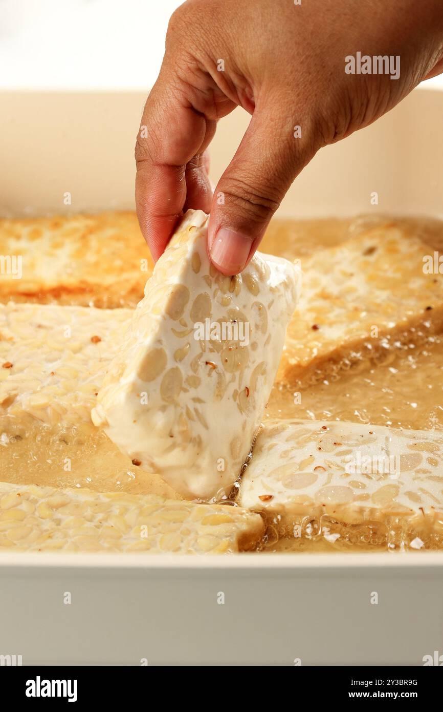 Put Sliced Tempeh to the Pan with Hot Oil, Female Hand Cooking Frying ...