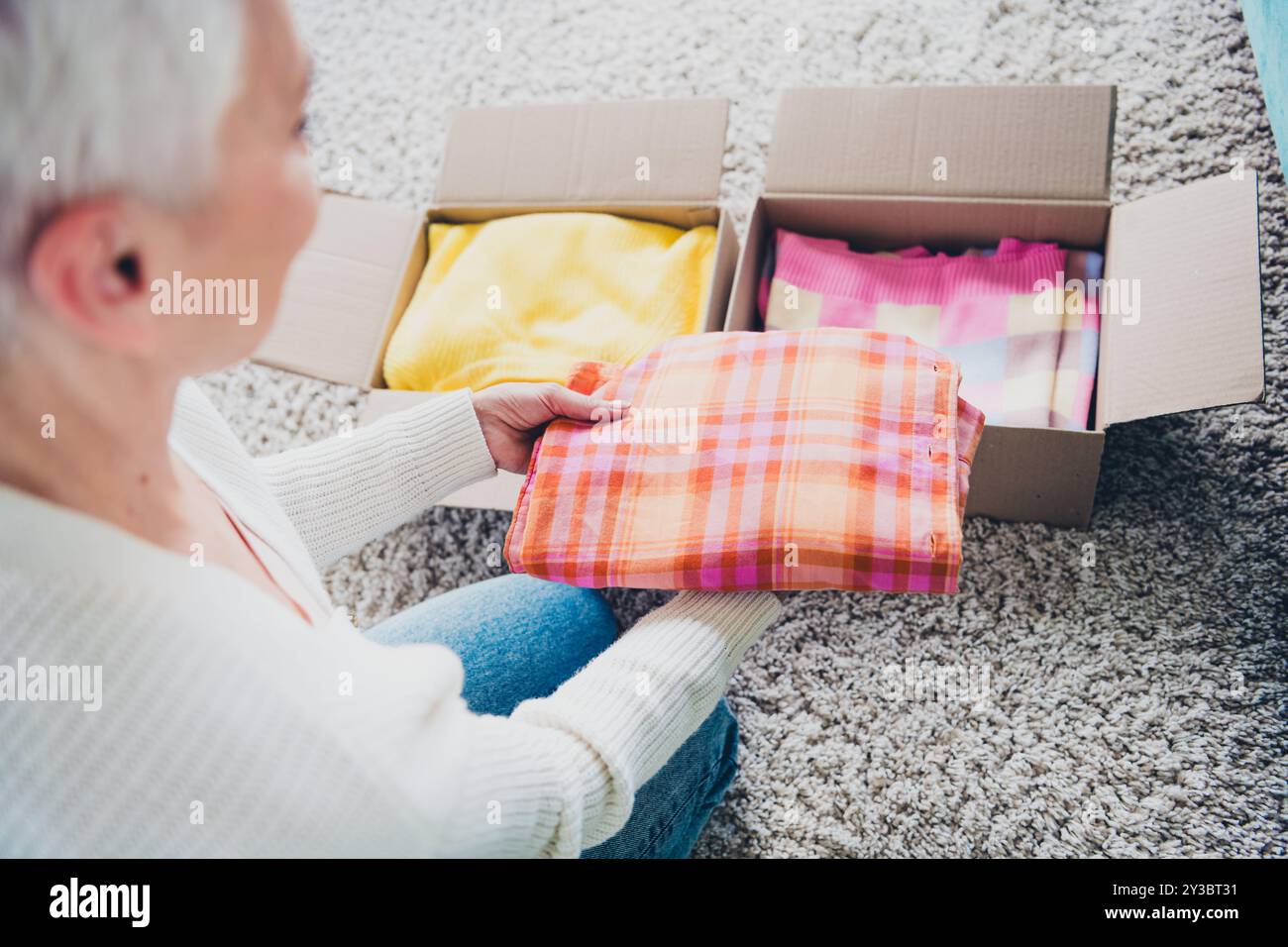 Photo of mature woman sitting floor packing parcel package order ...