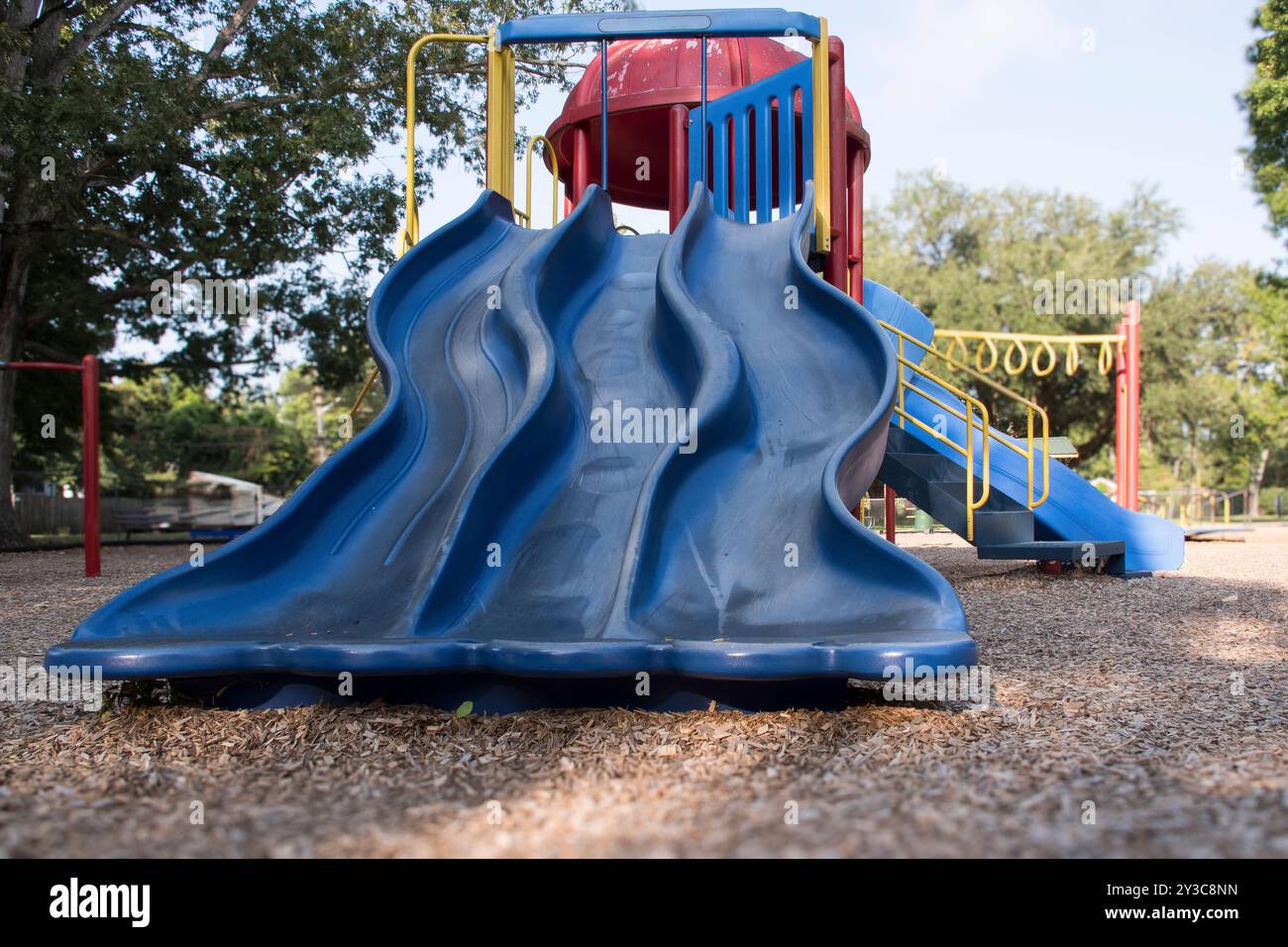 A multi slide piece of playground equipment stands ready for use in a ...