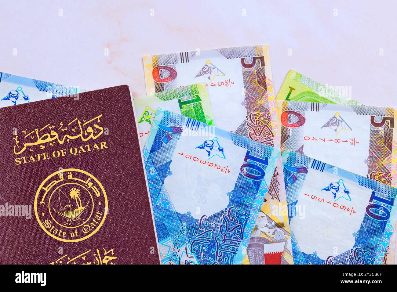 Passport of the State of Qatar issued with Qatari banknotes in currency ...