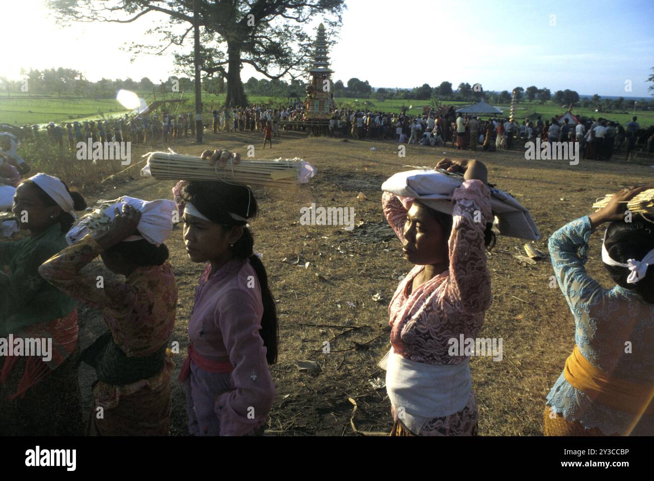 Ngaben (cremation ceremony), at the cremation site woman carry the ...