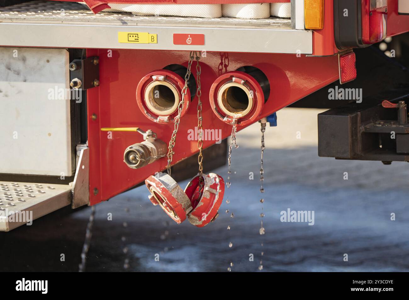Fire engine with open water connections and dripping water from the ...