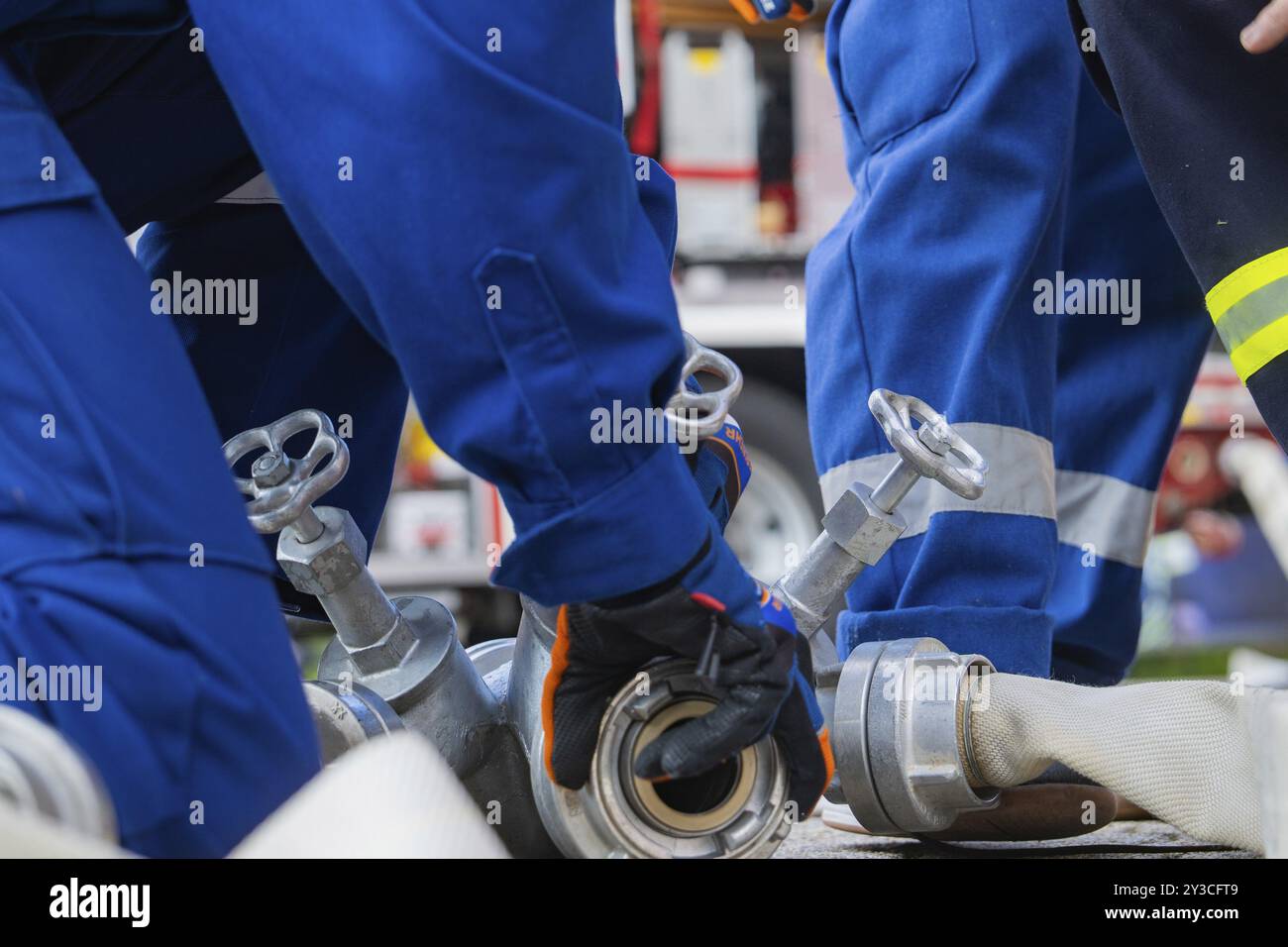 Firefighters in blue uniform working with fire hoses and metal ...