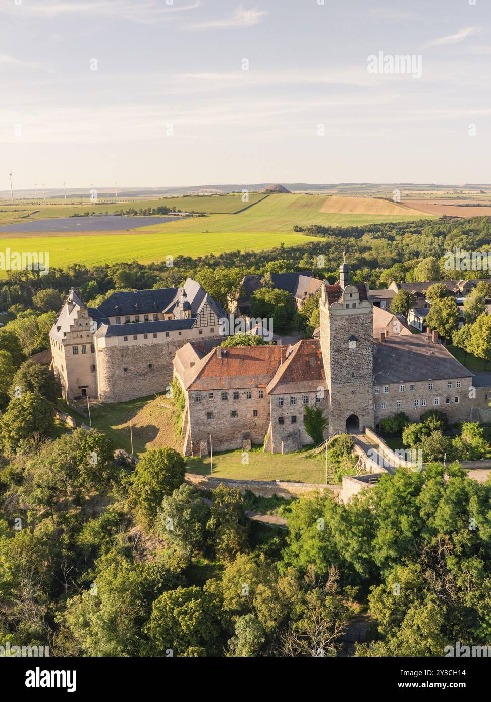 Aerial view of a wide medieval castle, embedded in green landscape and ...