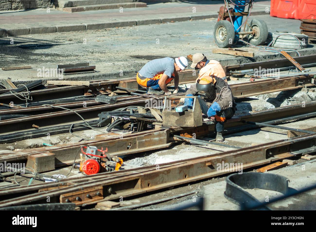 Group of workers welding rails, repairing tram tracks. Urban renovation ...