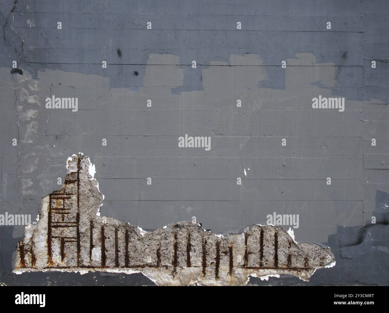 An old grey painted concrete wall with corroding rusty steel ...