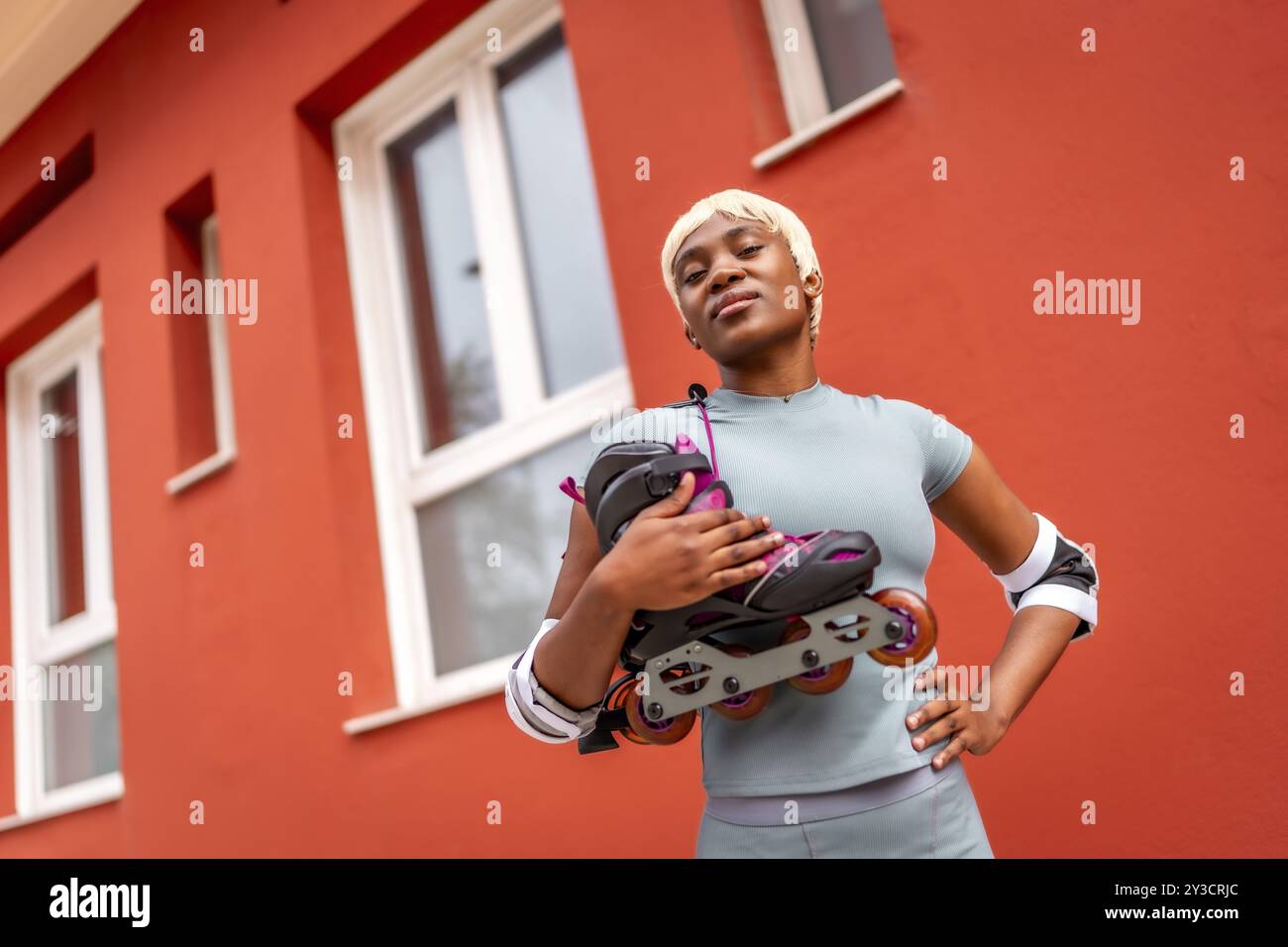 Confident and proud african woman carrying inline skates on shoulders ...