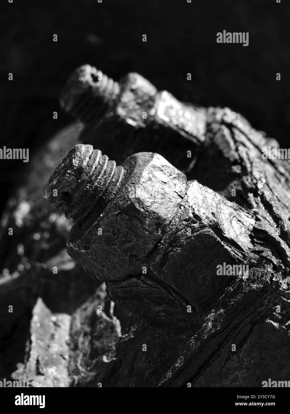 A monochrome close up of rusted threaded bolts and nuts on old corroded ...
