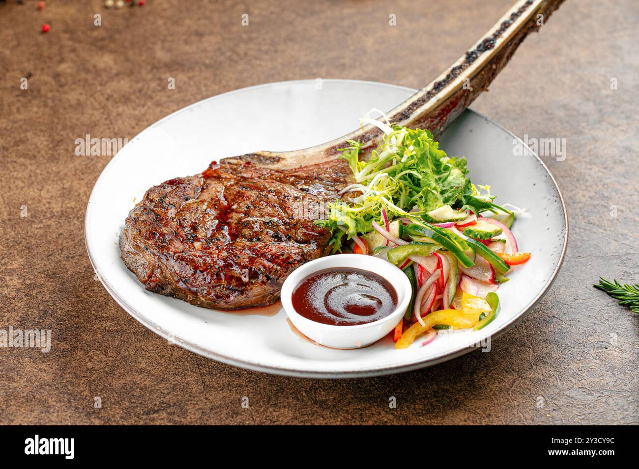 Grilled tomahawk steak with salad and sauce Stock Photo - Alamy