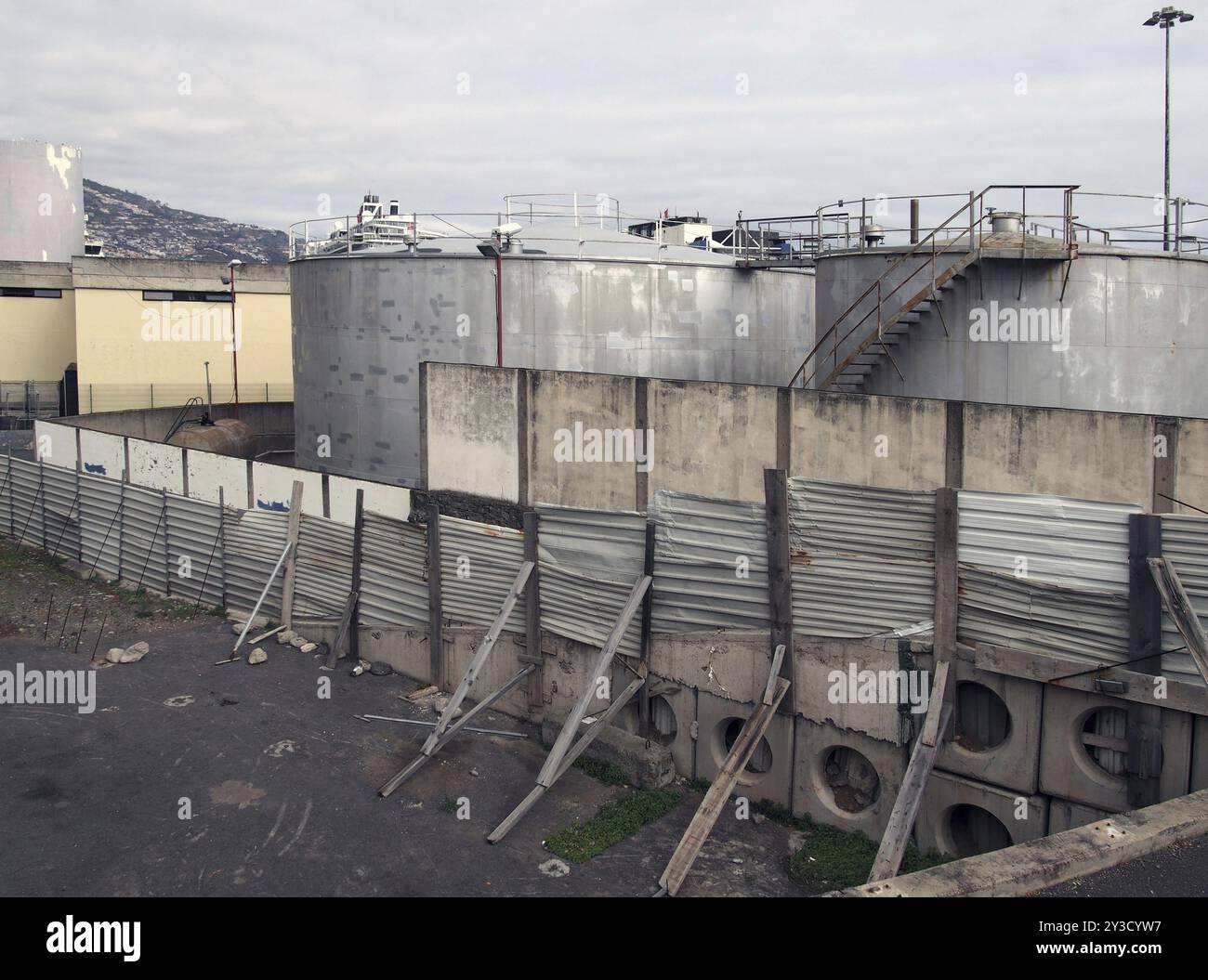 Old metal industrial storage tanks with rusty inspection ladders and ...