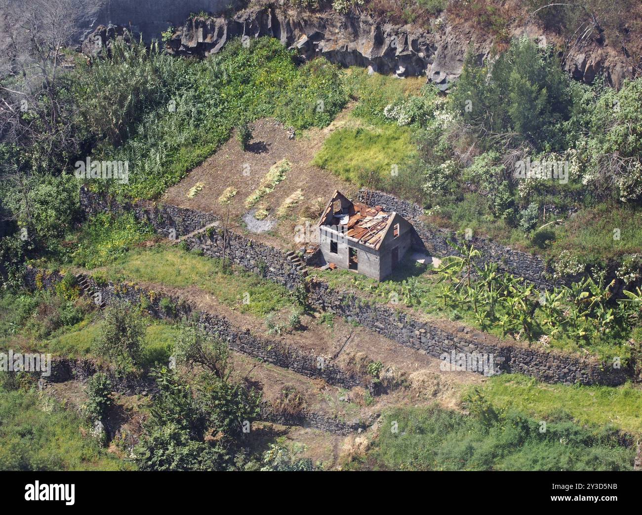 An aerial view of a ruined abandoned farmhouse surrounded by walled ...