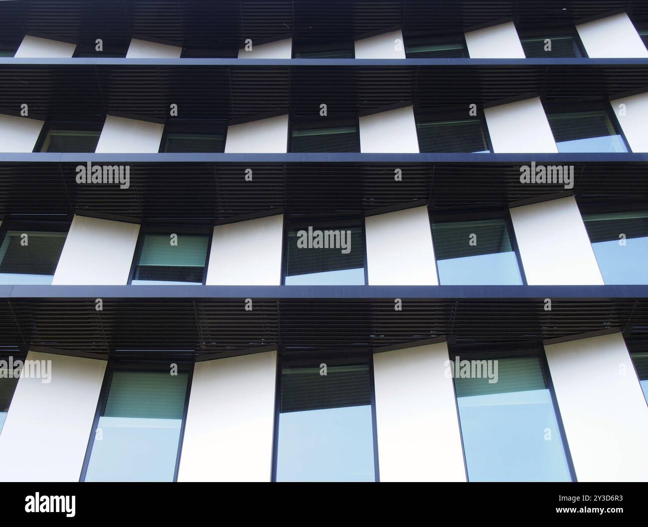 The facade of a futuristic modern building with angled geometric panels ...