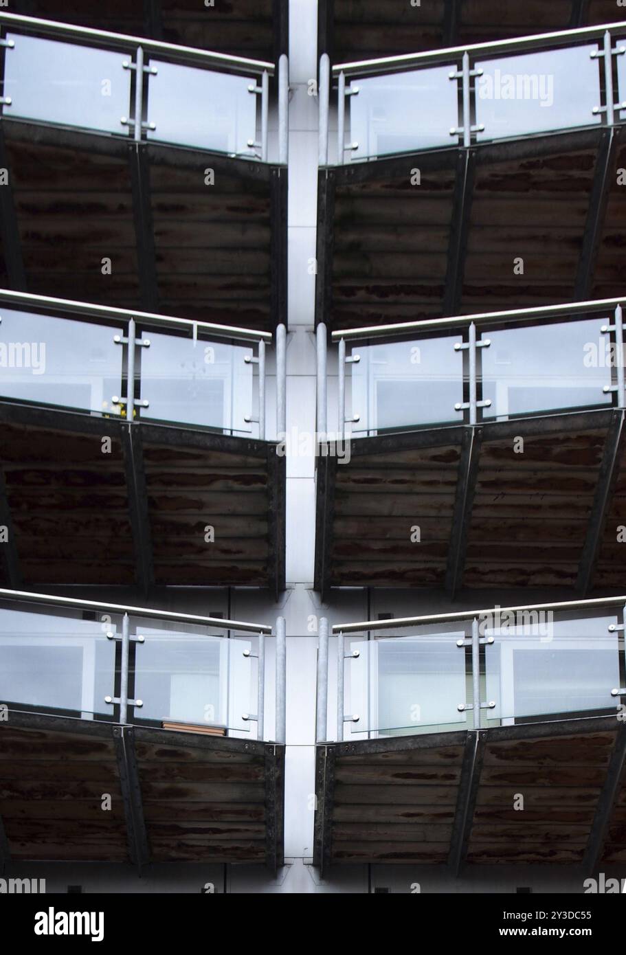 Vertical perspective view of angled modern glass apartment balconies on ...