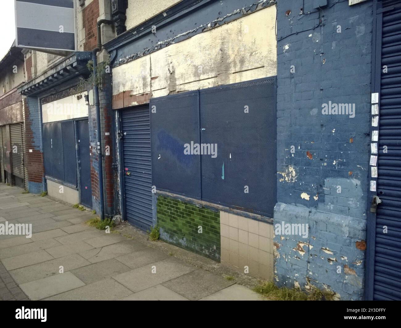 A row of abandoned stores with boarded up shop fronts with crumbling ...