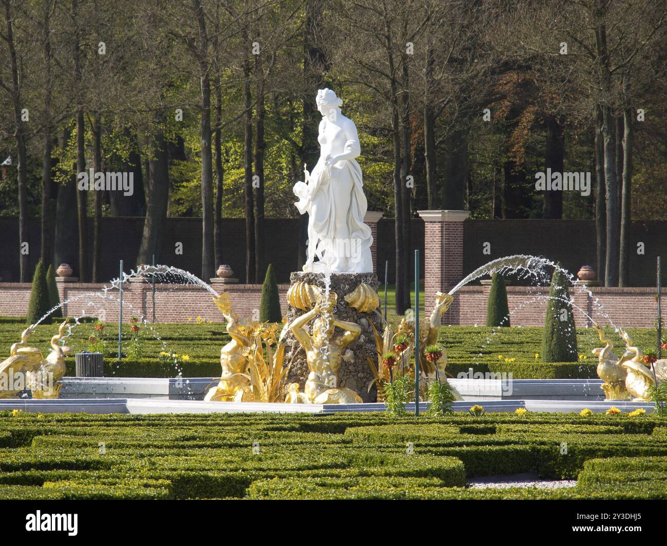 Fountain with a white statue and golden sculptures in a well-tended ...