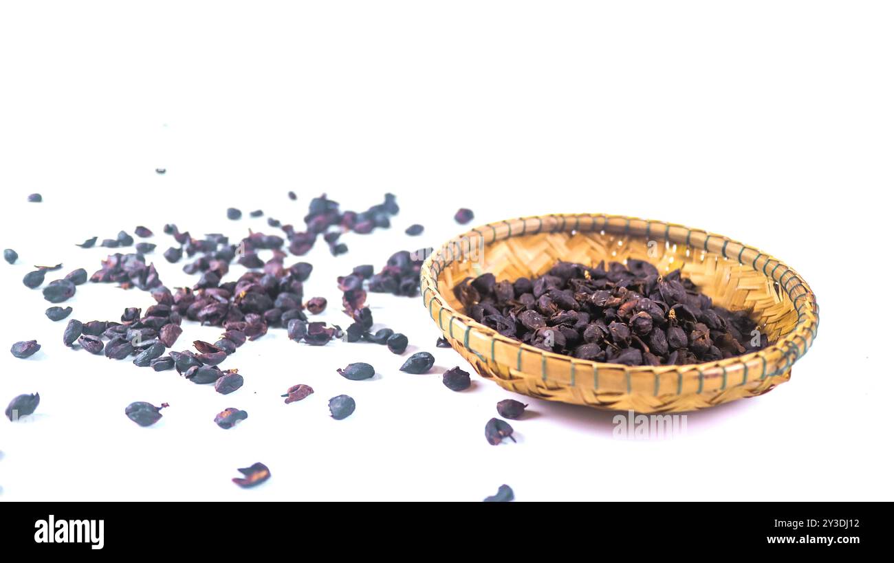 Isolated dark, dried coffee bean husks in bamboo basket and on a white ...