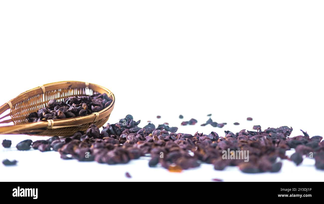 Isolated dark, dried coffee bean husks in bamboo basket and on a white ...