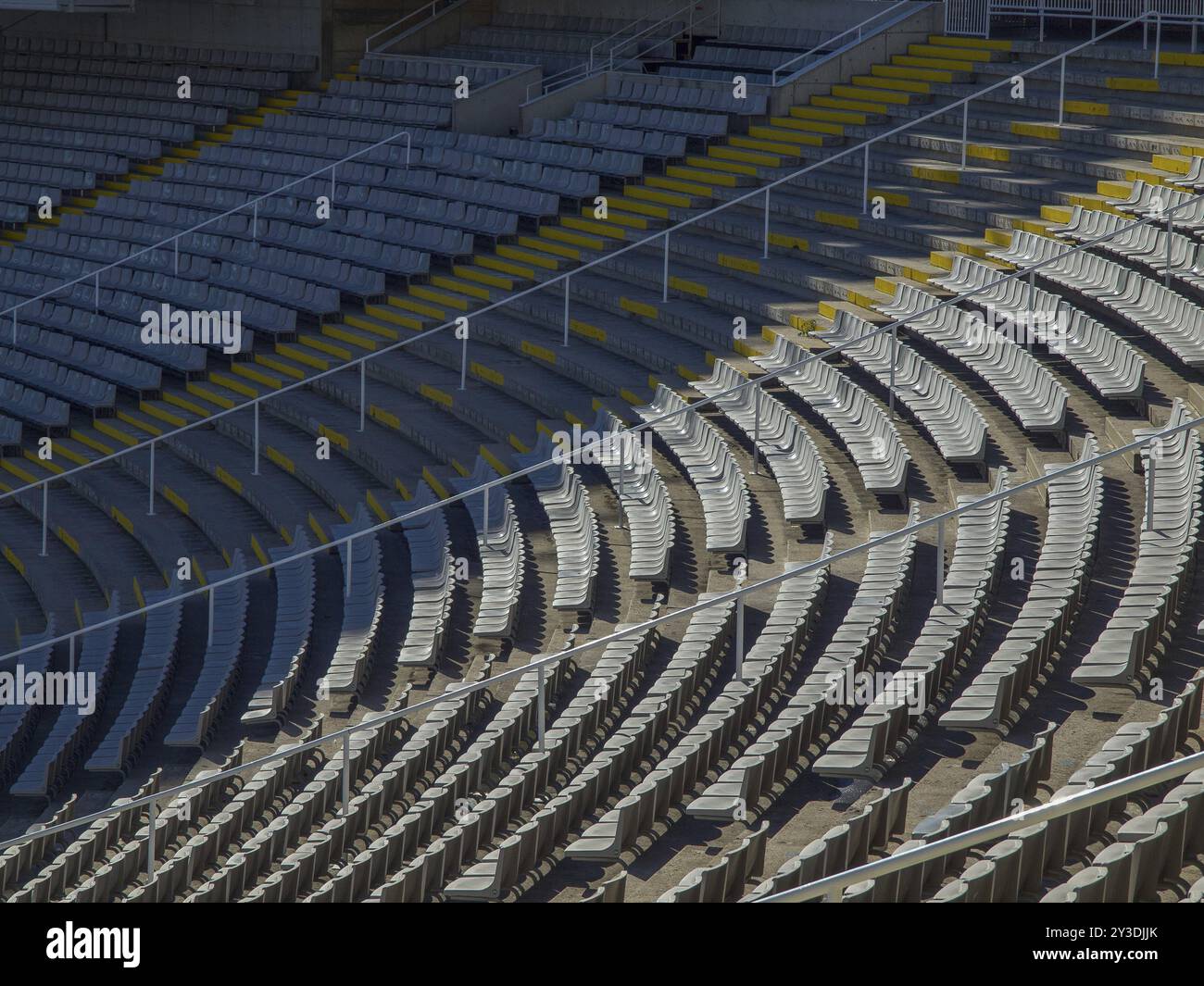 Empty stadium stands with tiered rows of seats and yellow steps in ...