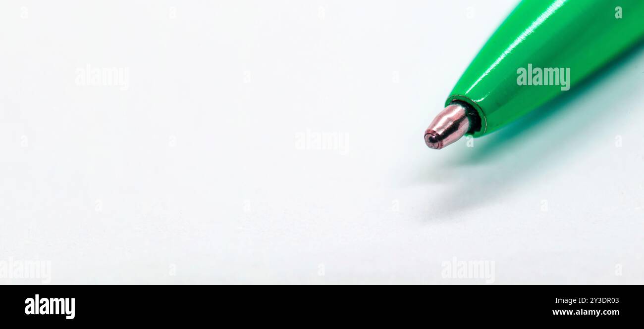 Top view of green pen on wide white paper with customizable space for ...