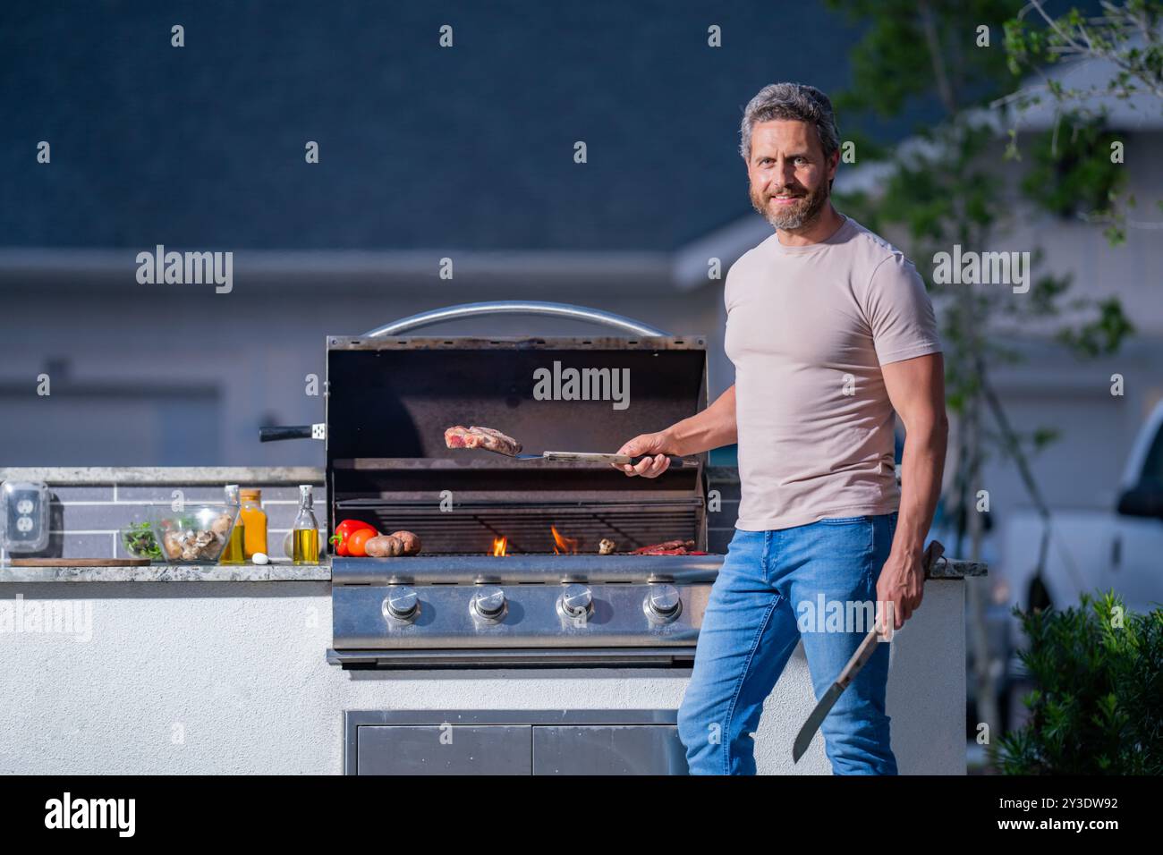 Male chef grilling and barbequing in garden. Barbecue outdoor garden ...