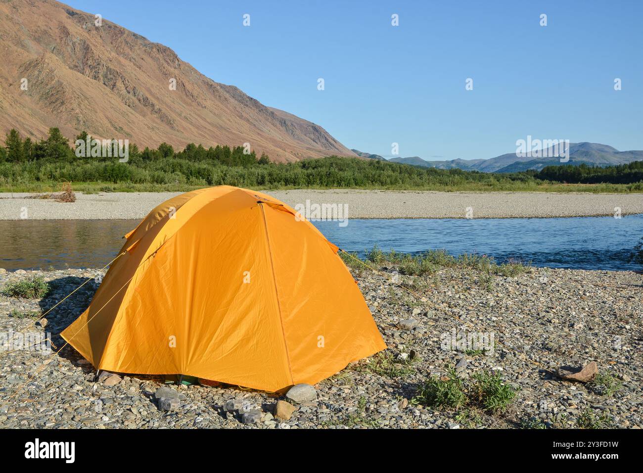 Travel to the Polar Urals. Orange tent against the backdrop of Mount ...