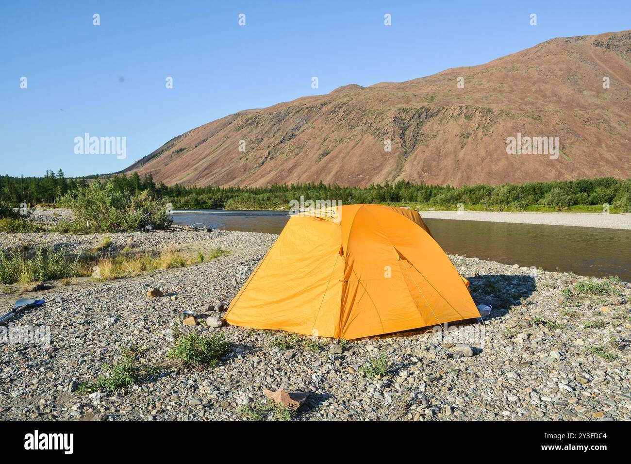 Travel to the Polar Urals. Orange tent against the backdrop of Mount ...