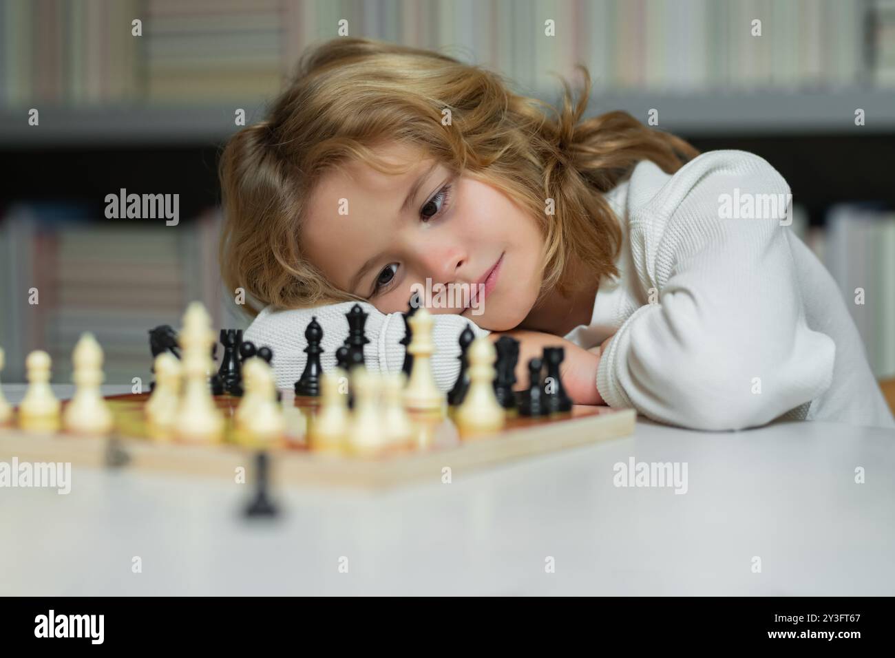 Concentrated child play chess. Kid playing board game. Kids early ...