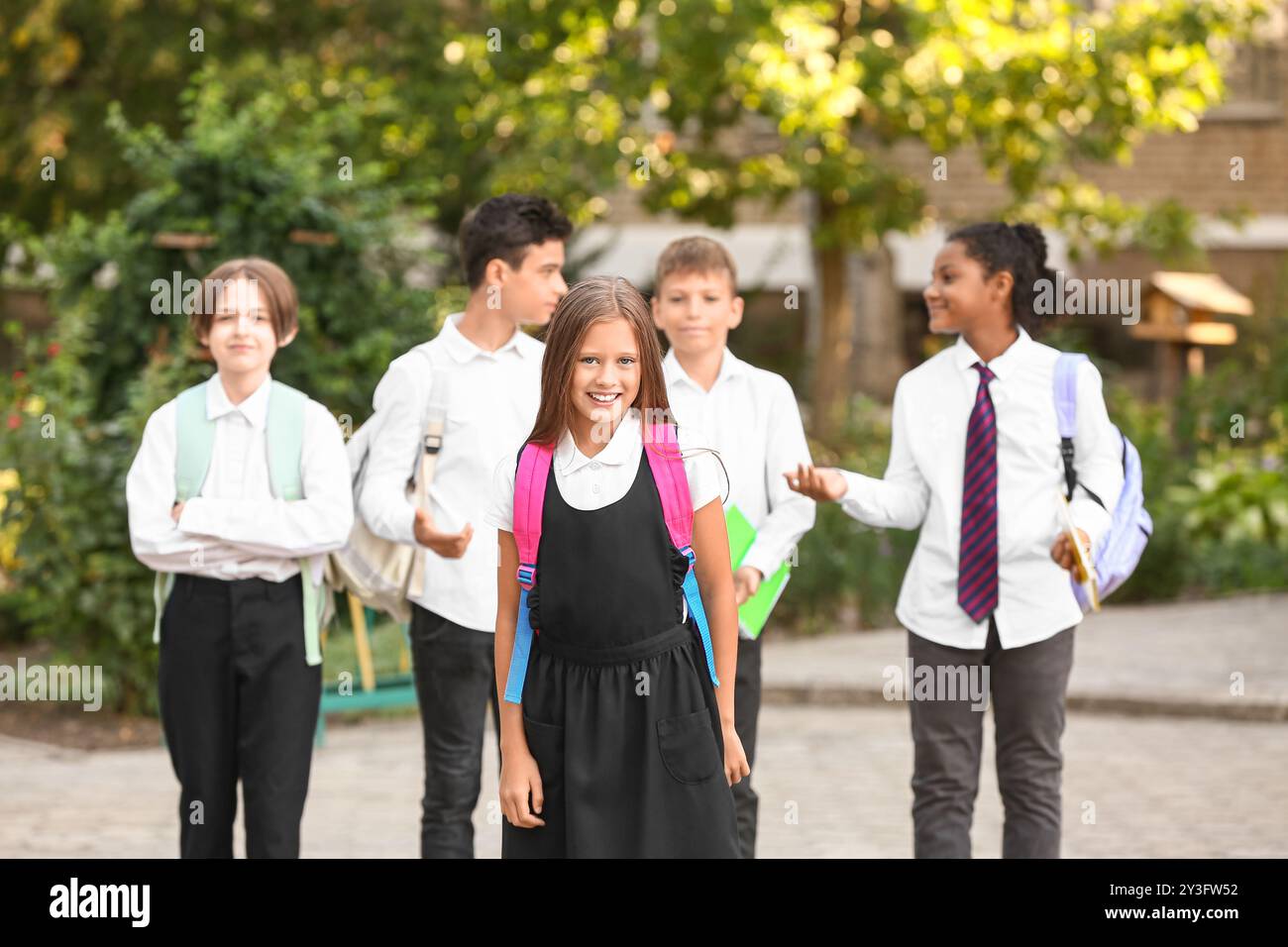 Cute happy girl with her happy classmates before school outdoors Stock ...