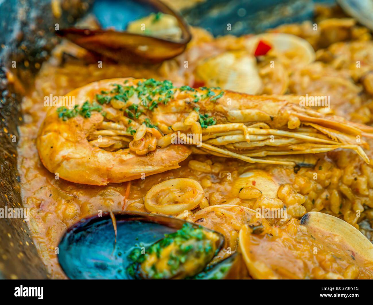 The traditional Spanish seafood dish called Paella in a black pan with ...